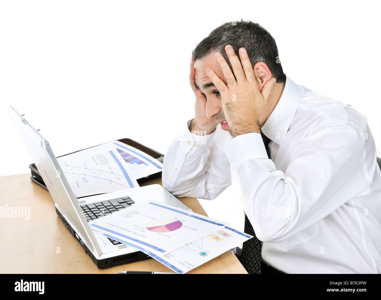 Stressed businessman sitting at his desk isolated on white background ...
