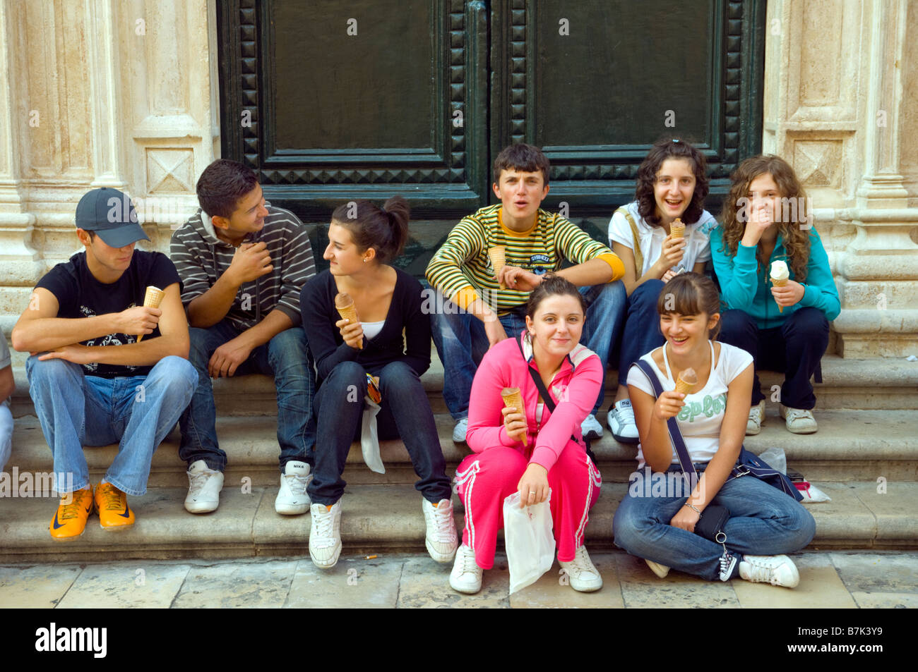 A group of young school students pose for pictures in the old town of ...