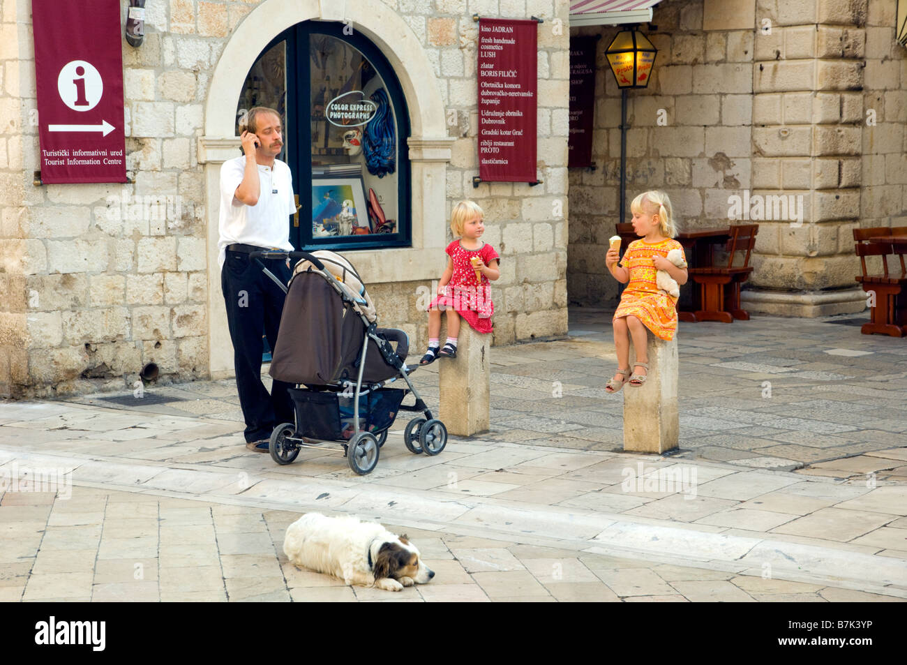 A young family with two girls eating ice cream in old town Dubrovnik ...
