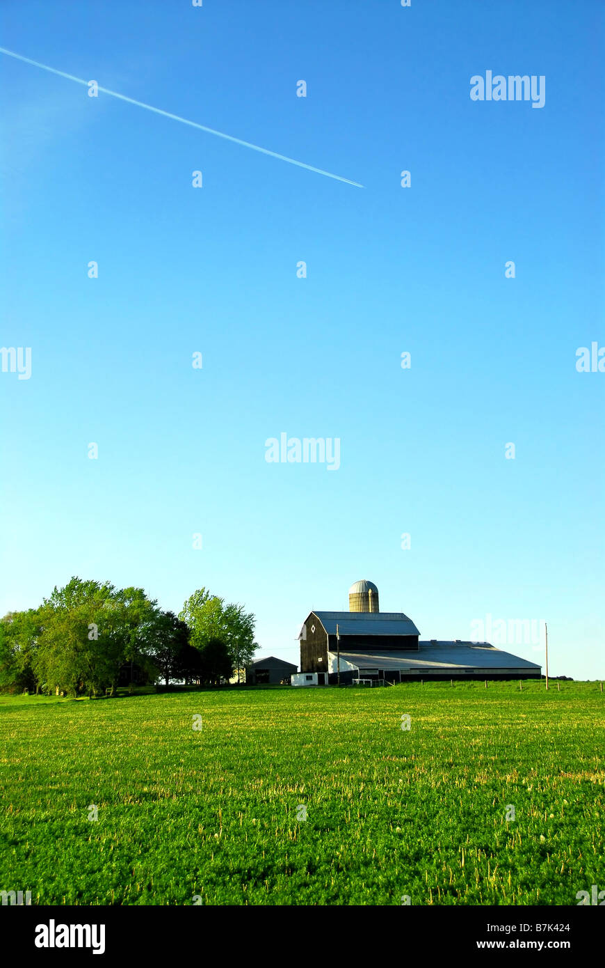 Farmhouse and barn among green fields vertical Stock Photo - Alamy