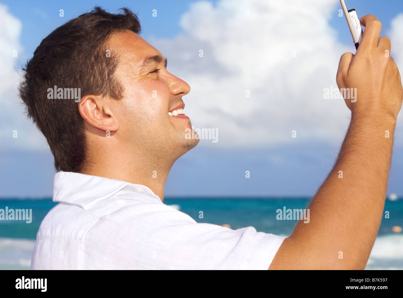 happy man with cell phone on the beach Stock Photo - Alamy
