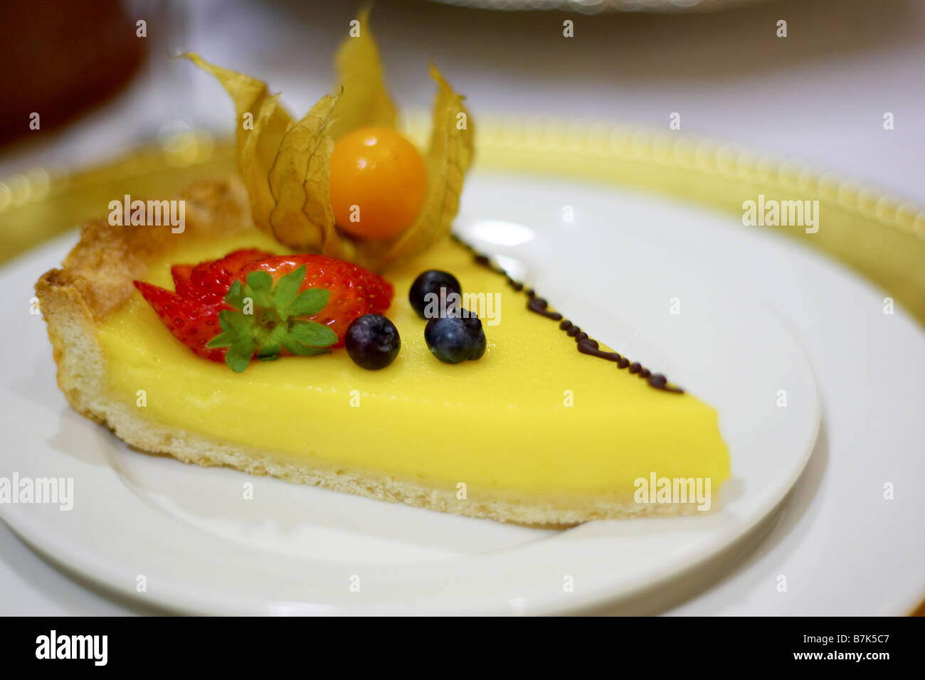 Piece of lemon fruit flan dessert on white plate Stock Photo - Alamy