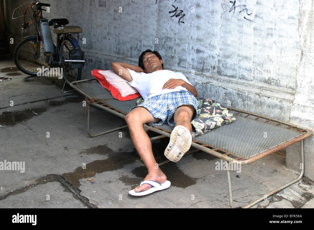 Sleeping Chinese on a street of Shanghai. People take a nap anywhere ...