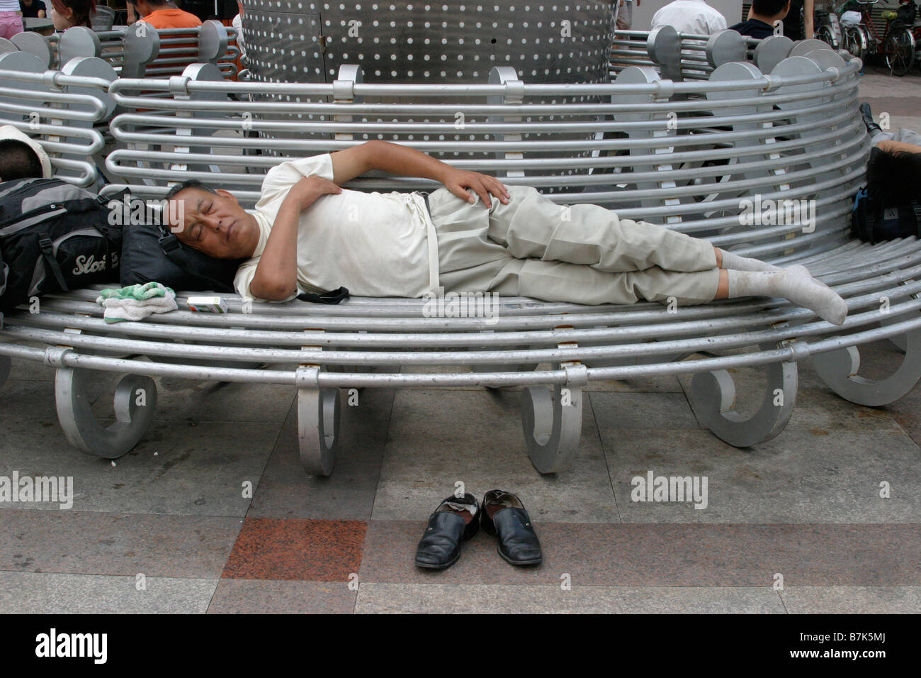Sleeping Chinese on a street of Shanghai. People take a nap anywhere ...