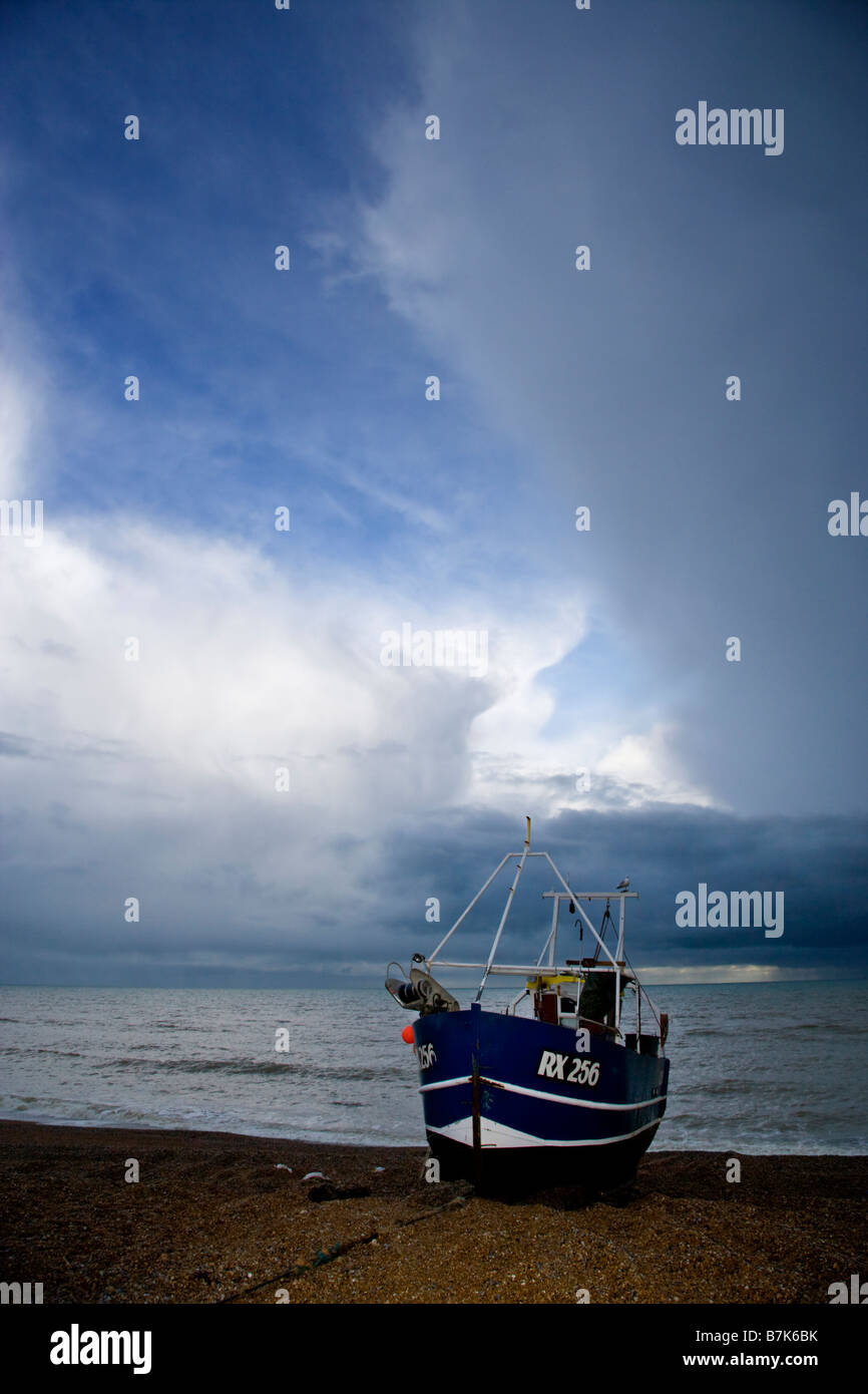 A fishing boat beached on the shingle shore at Hastings against a ...