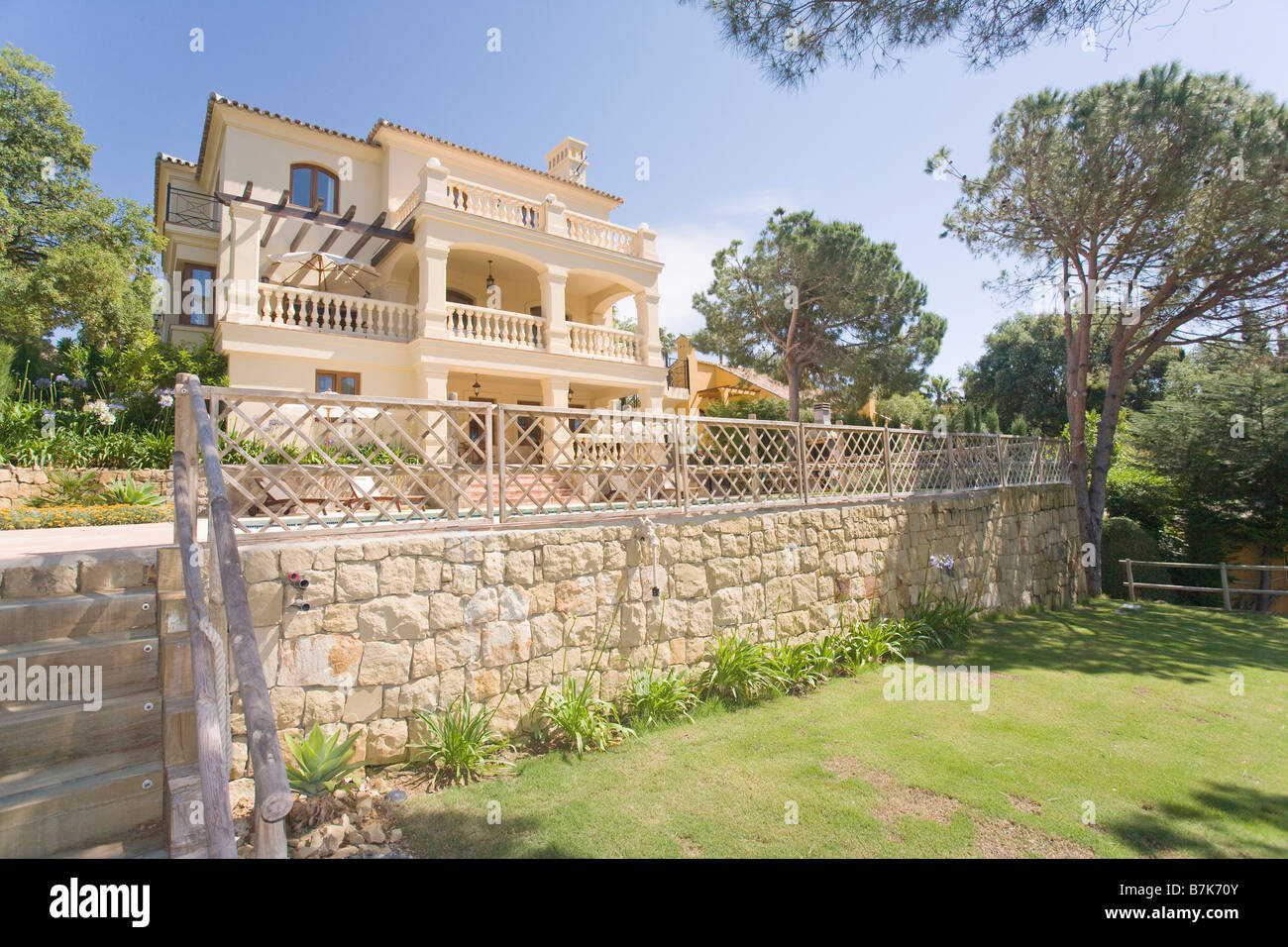 Large detached villa with balconies and sunken garden with stone wall ...