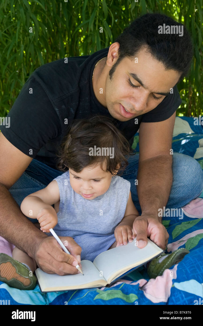 Hispanic father teaching his son to write Stock Photo - Alamy