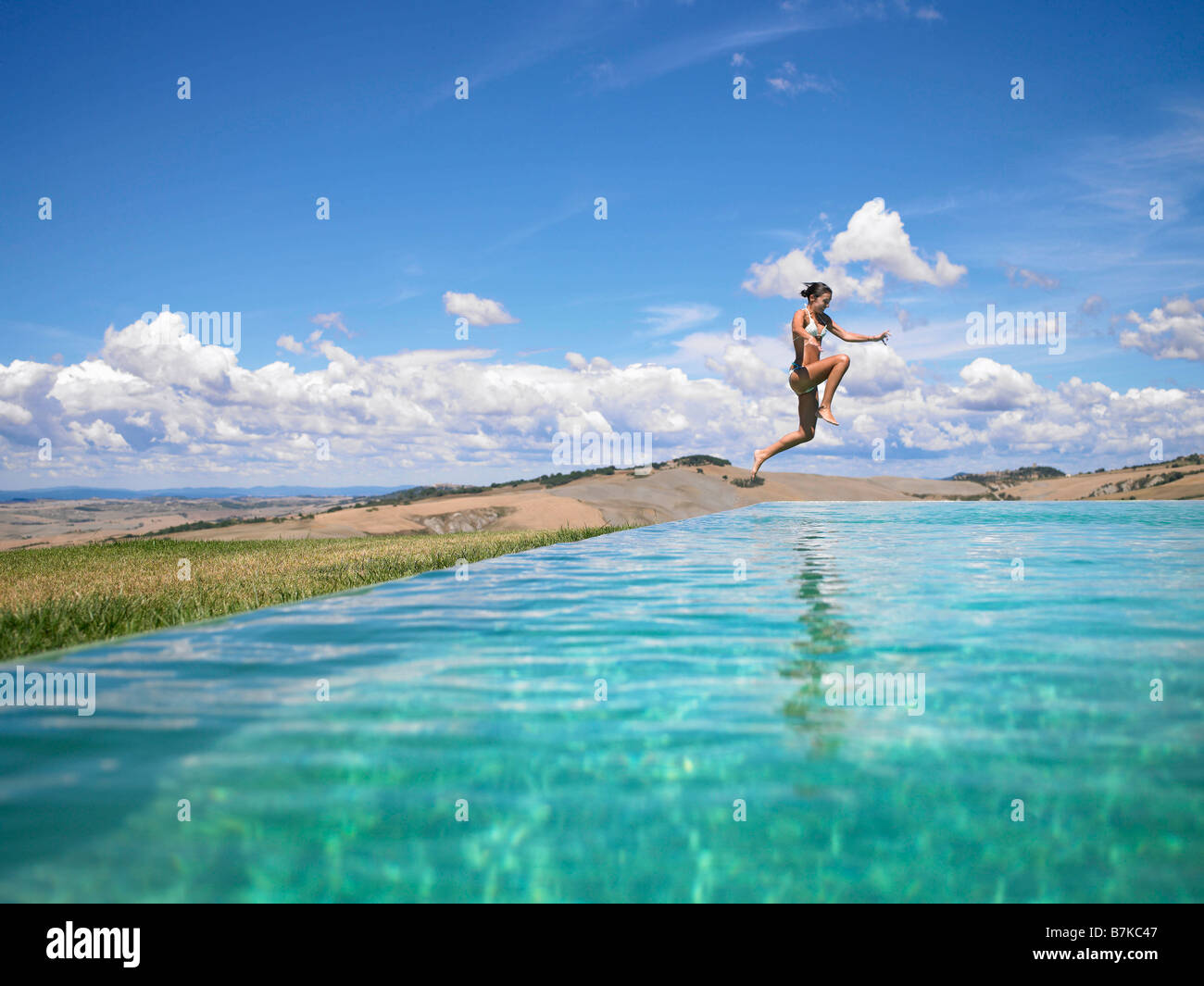 Woman jumping in swimming pool Stock Photo - Alamy