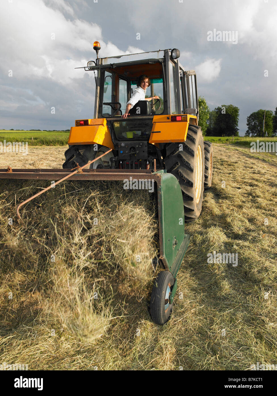 man driving tractor Stock Photo - Alamy