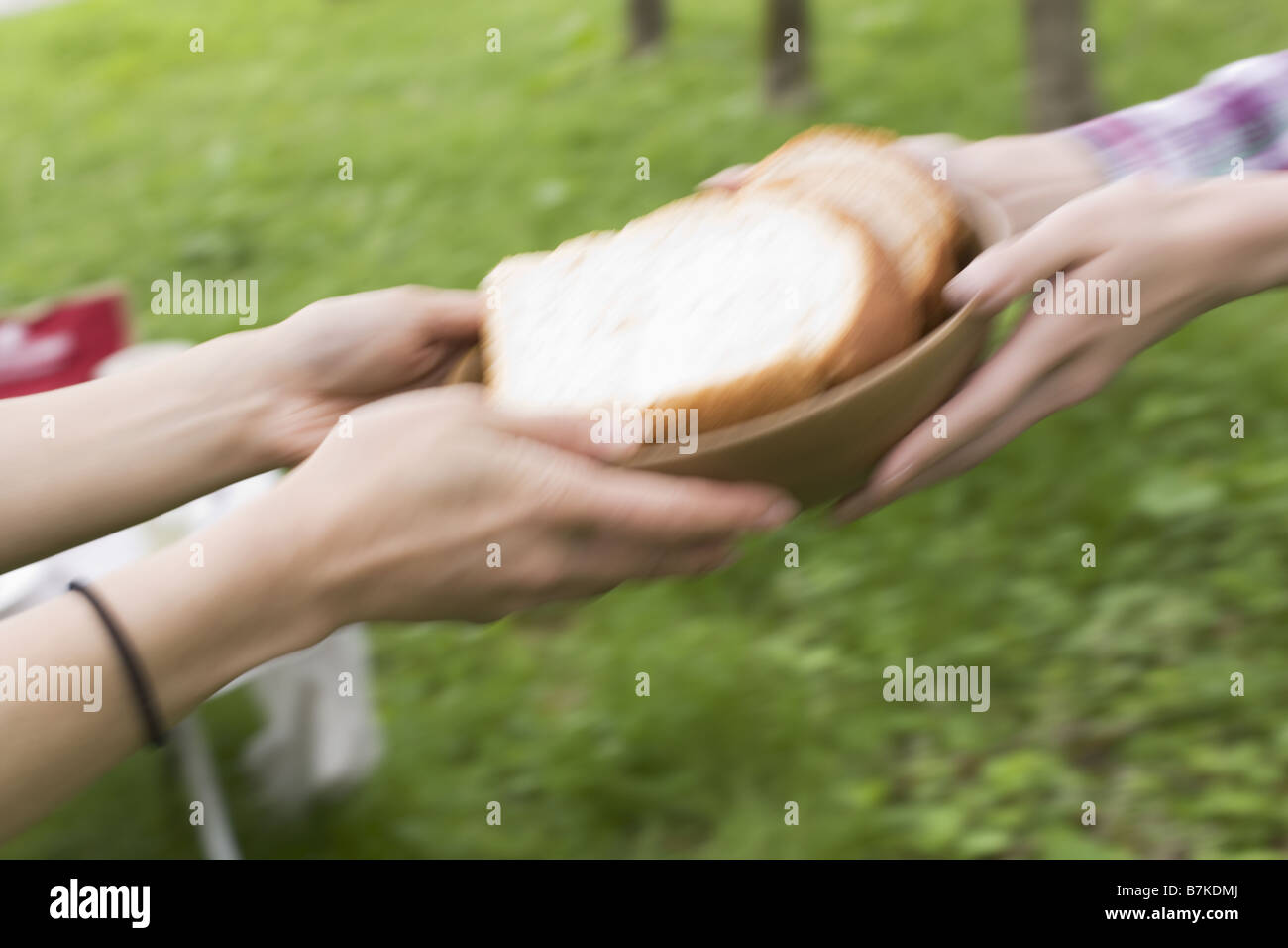 Woman Handing Breads to Partner Stock Photo - Alamy