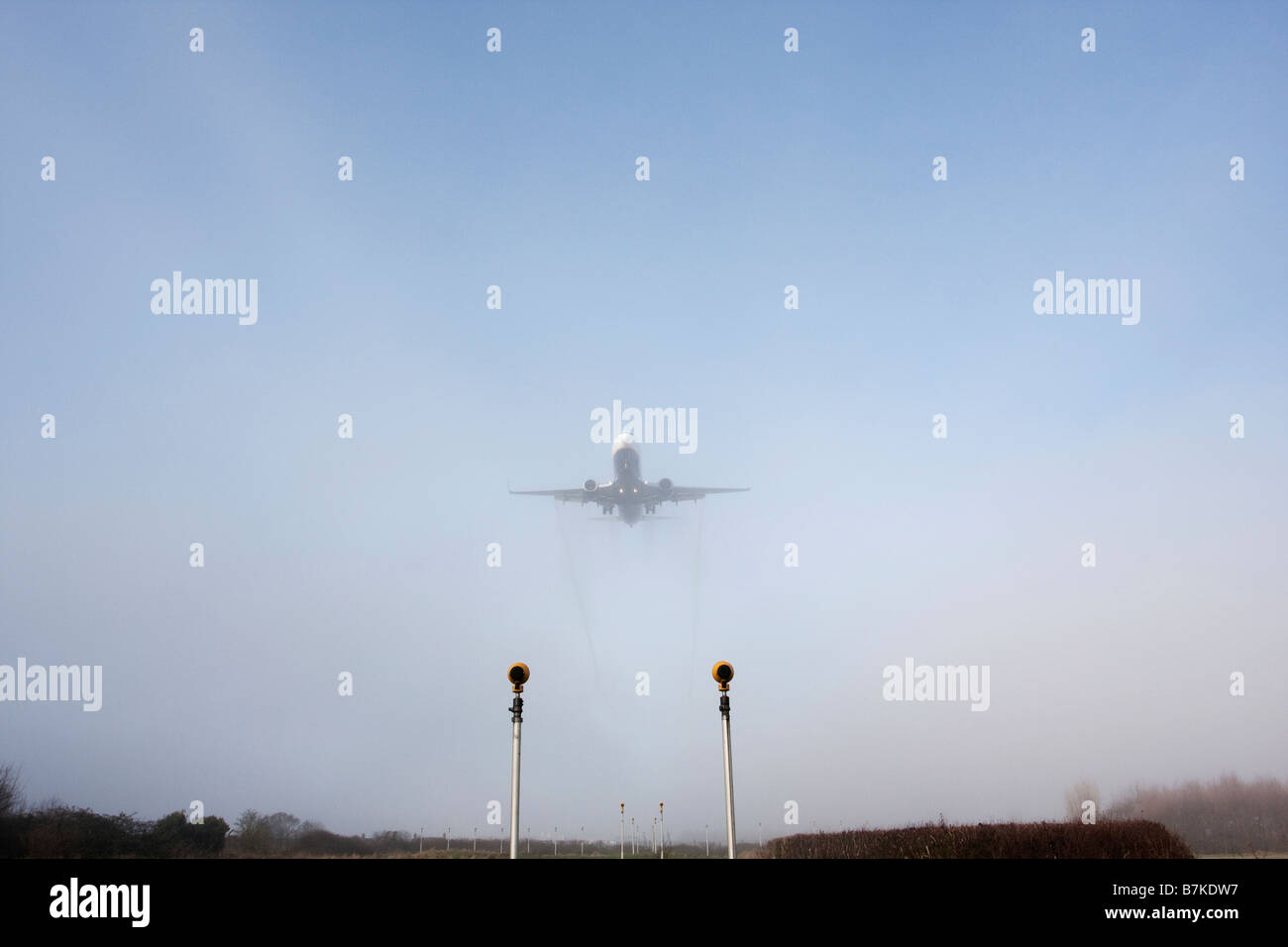 passenger jet over landing lights in winter mist Stock Photo - Alamy