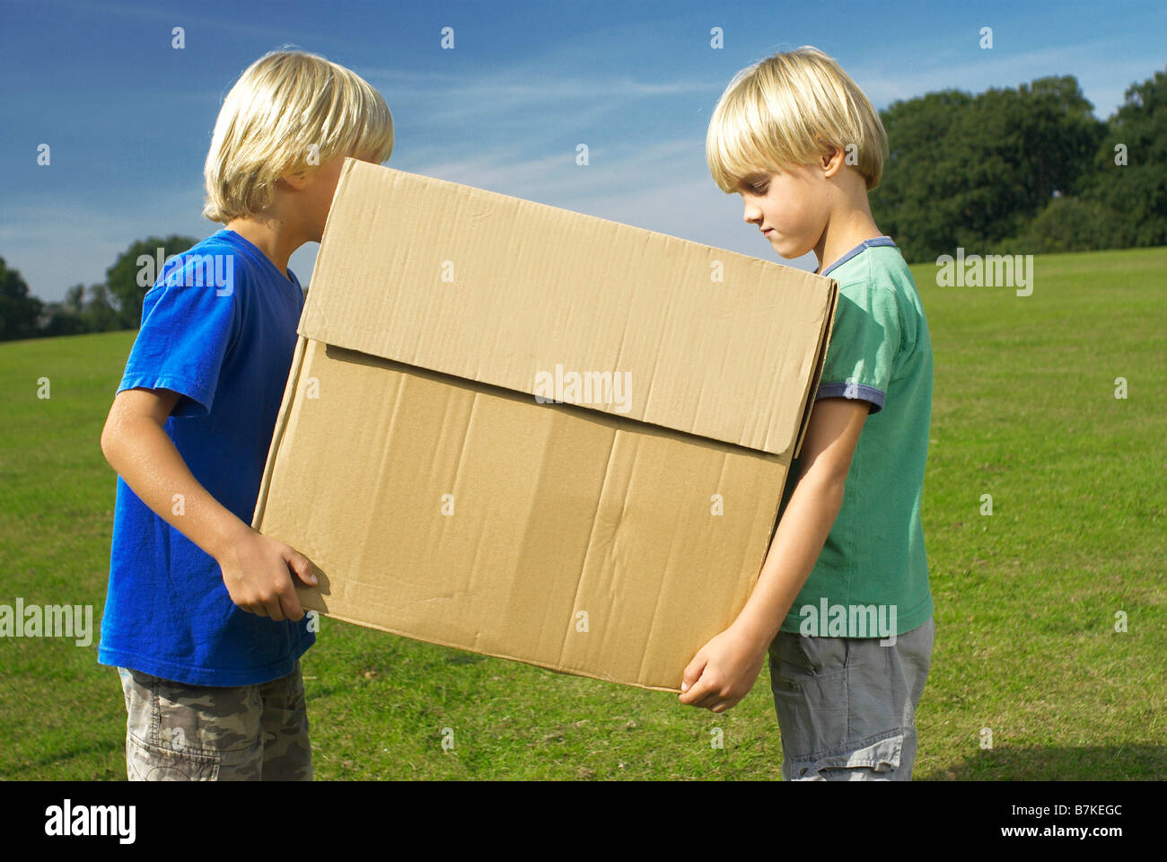 two boys holding box Stock Photo - Alamy