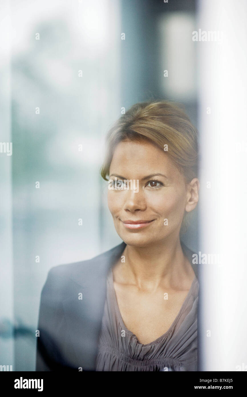 Woman looking through window, smiling Stock Photo - Alamy