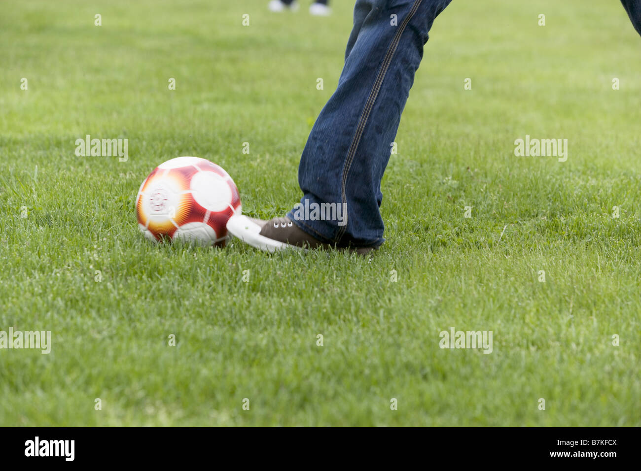 Young Man Kicking Ball Stock Photo - Alamy