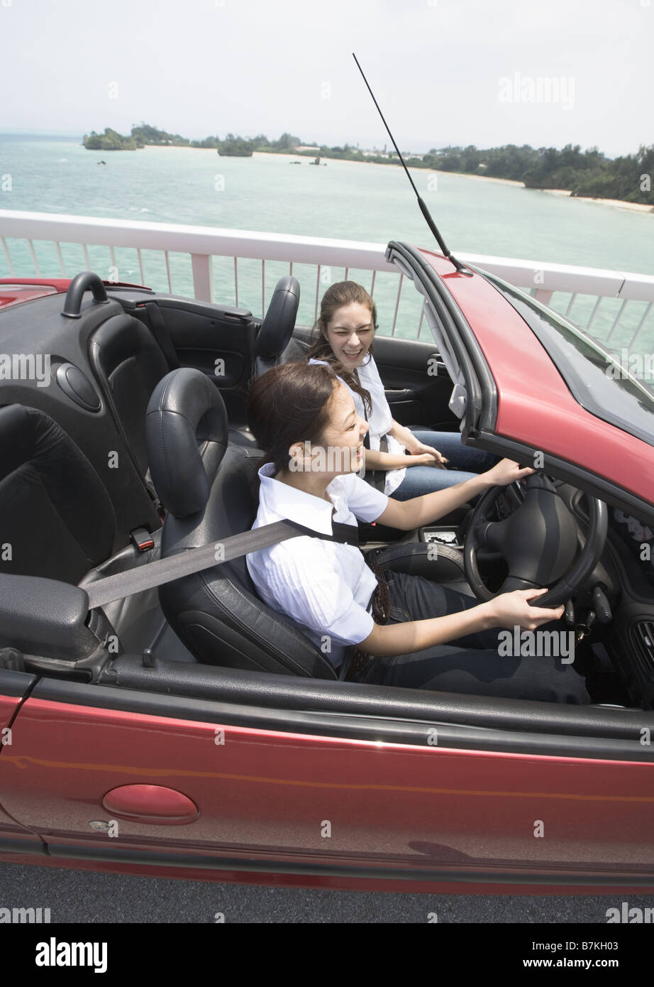Two women driving a convertible Stock Photo - Alamy