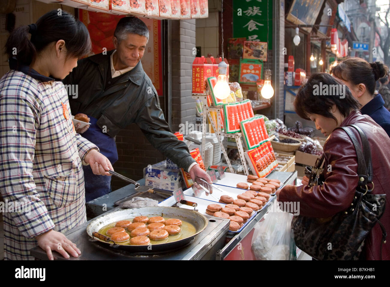 A shop cooking and selling traditional Hui Muslim cakes at a takeaway ...