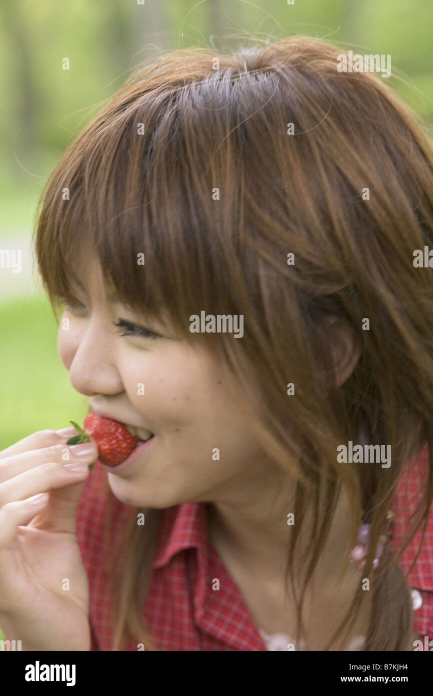 Woman Eating a Strawberry Stock Photo - Alamy