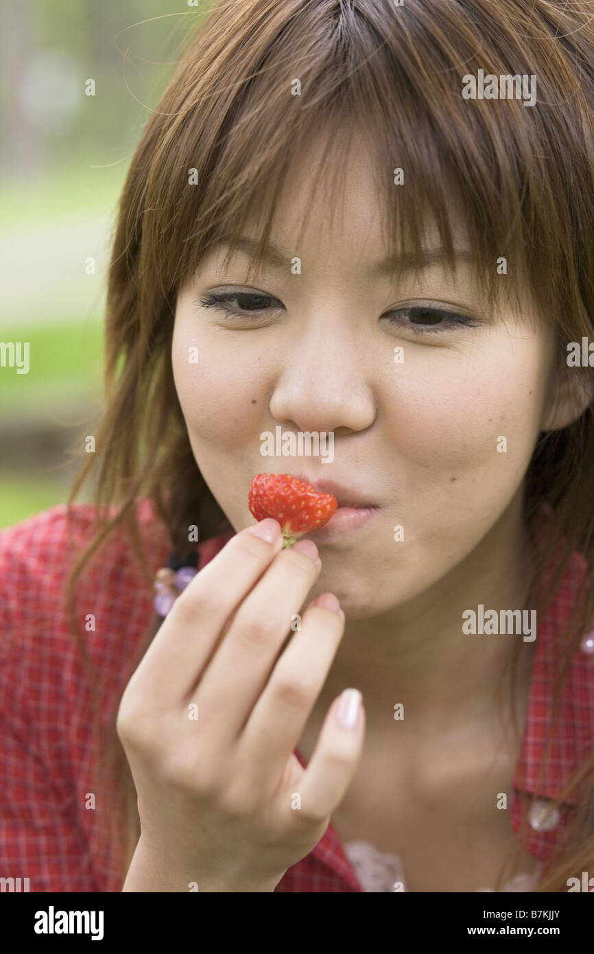 Woman Eating a Strawberry Stock Photo - Alamy