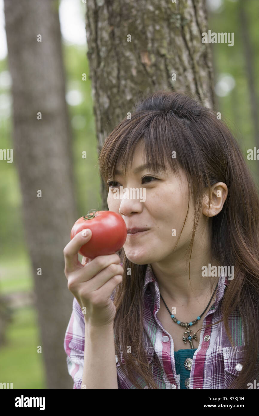 Woman Eating a Tomato Stock Photo - Alamy