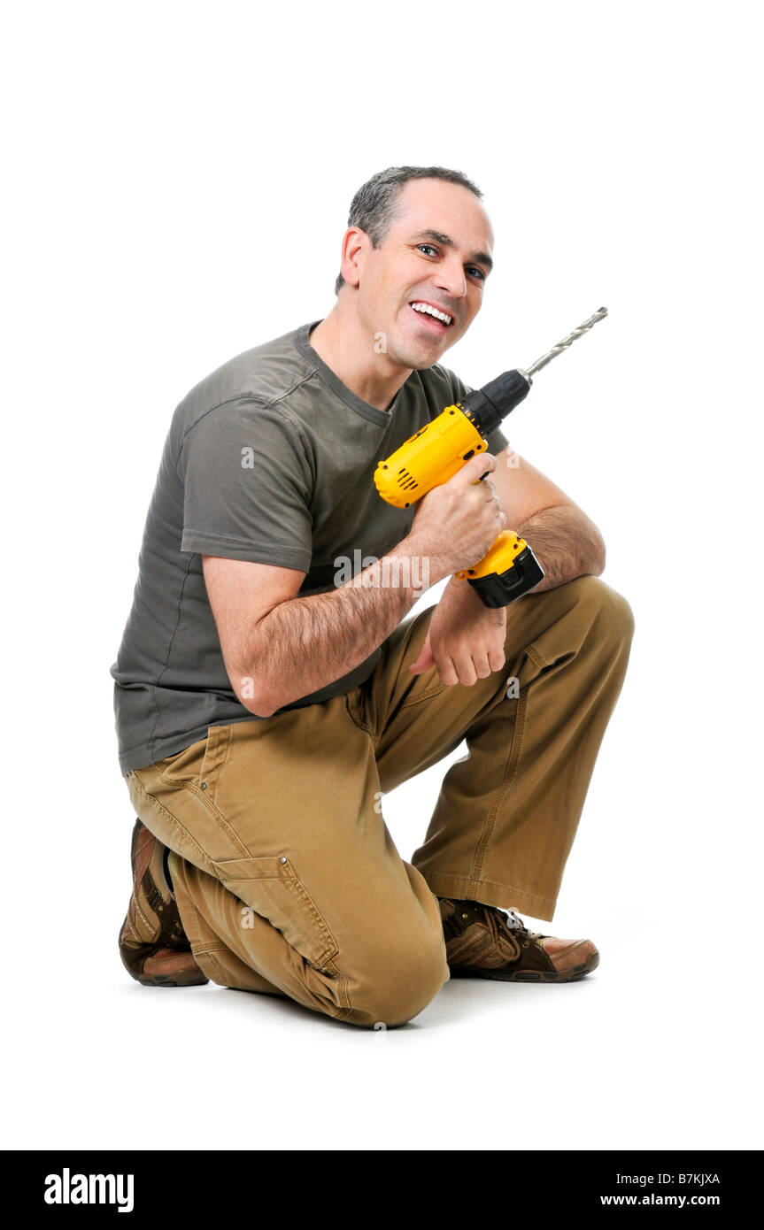 Kneeling happy handyman with his cordless drill Stock Photo - Alamy