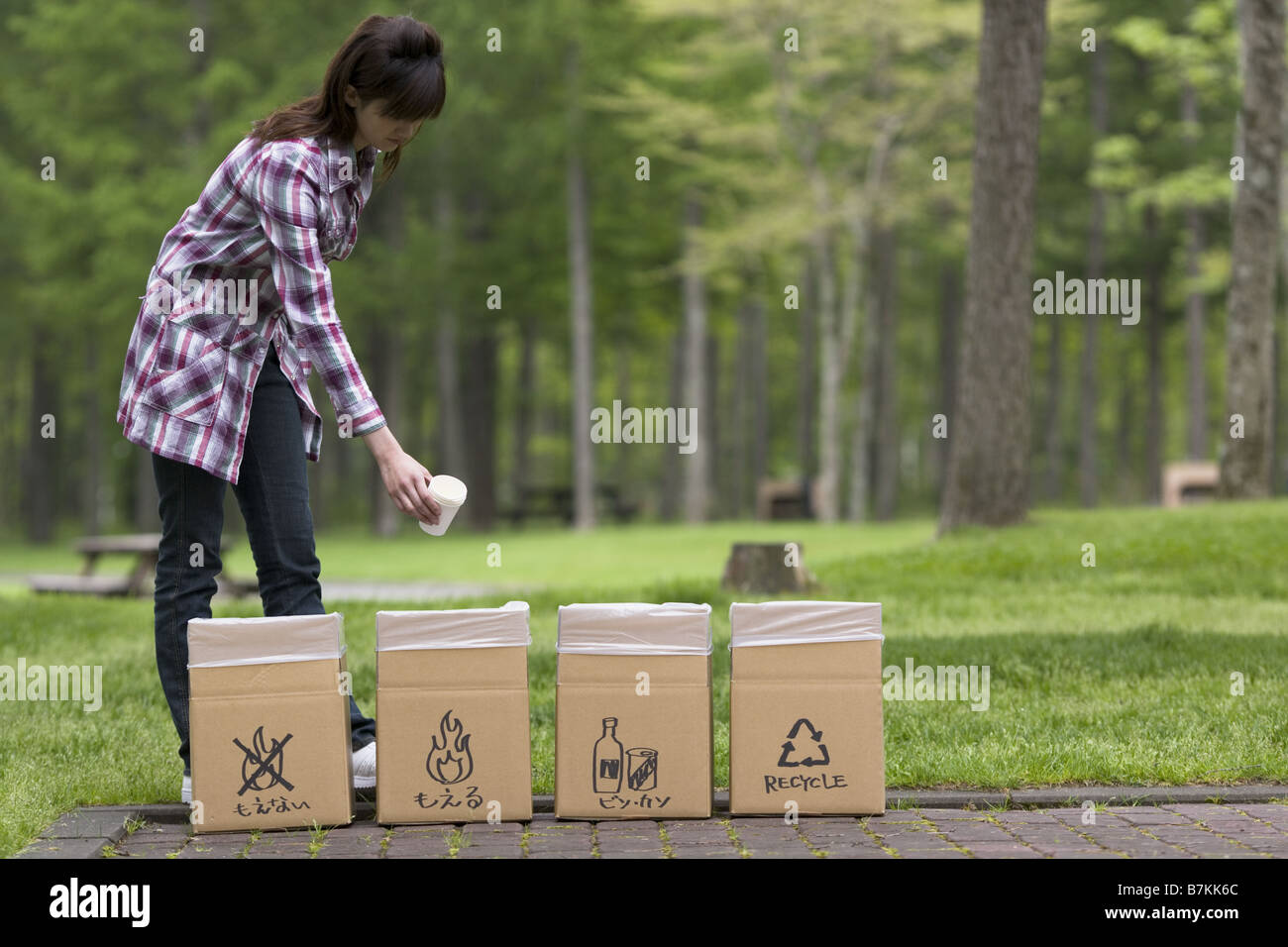 Woman Trowing Garbage into a Dust Bin Stock Photo - Alamy