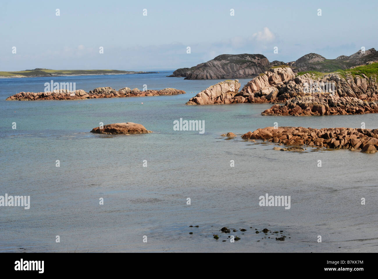 Pink granite rocks on the shoreline at Fionnphort on the Isle of Mull ...