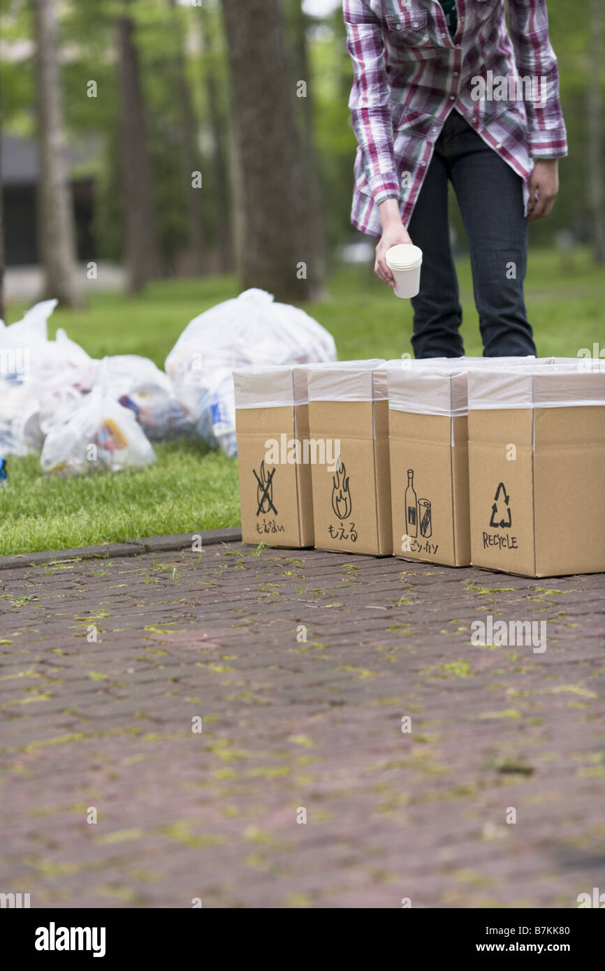 Woman Trowing Garbage into a Dust Bin Stock Photo - Alamy
