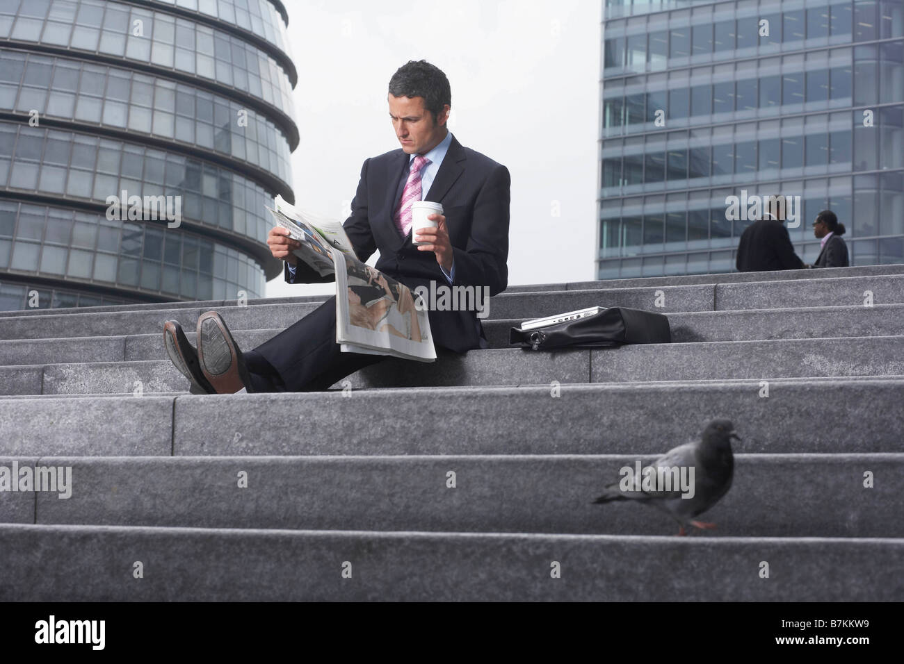Business man reading paper outside Stock Photo - Alamy