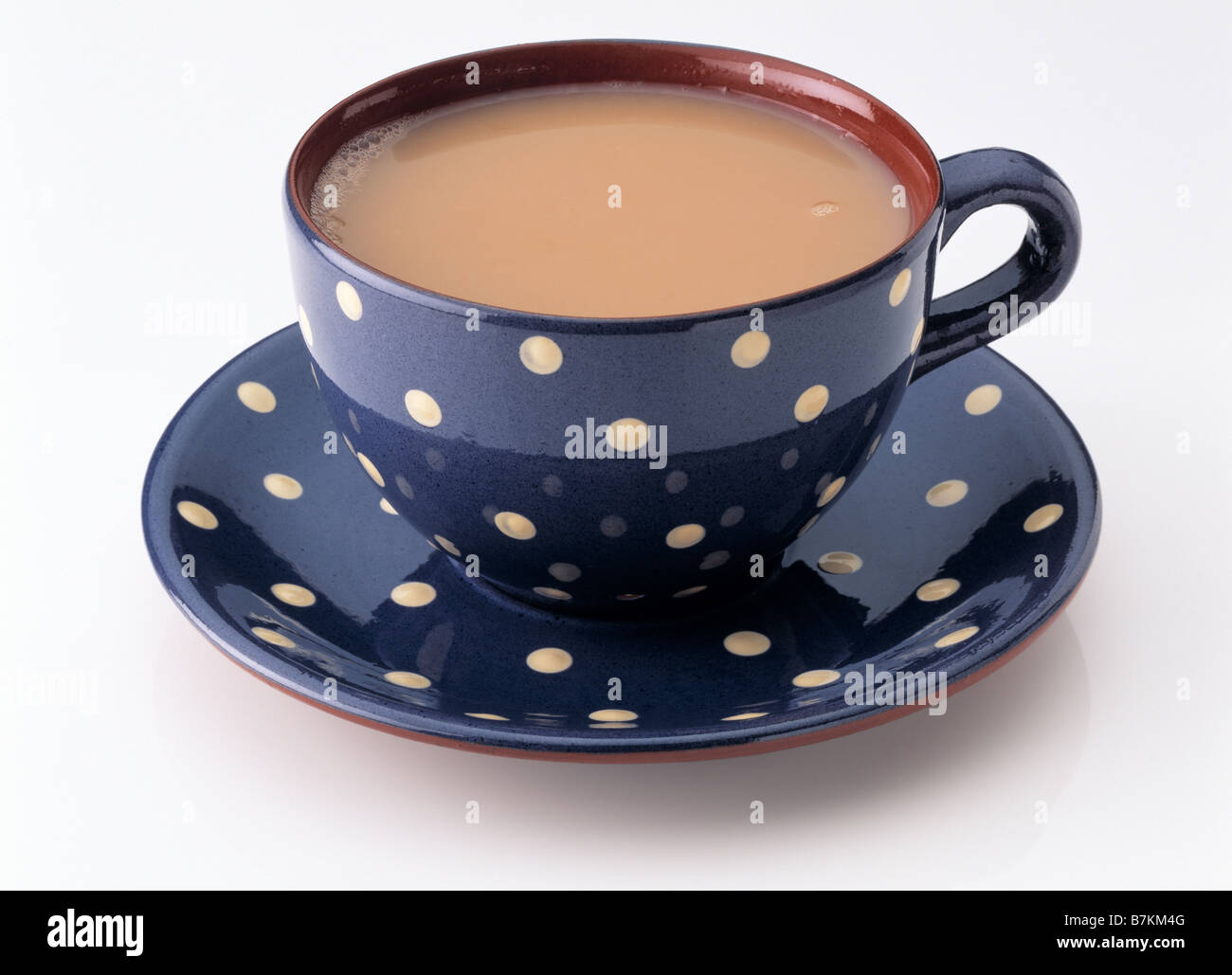 Blue and white spotted cup and saucer of tea on a white background ...