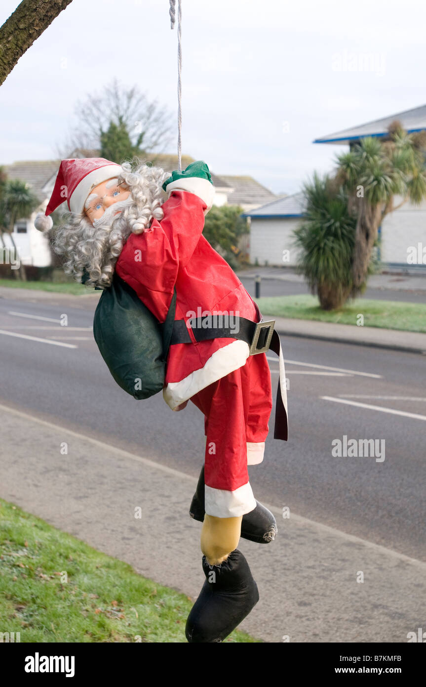 A Santa Clause puppet hanging from a tree Stock Photo - Alamy