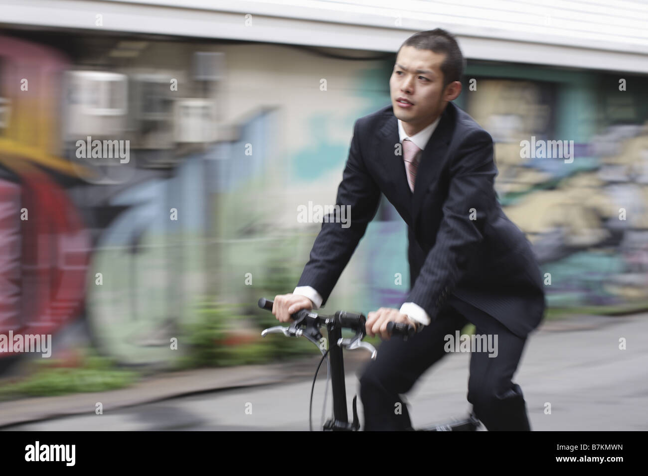 Businessman Riding Bike Stock Photo - Alamy