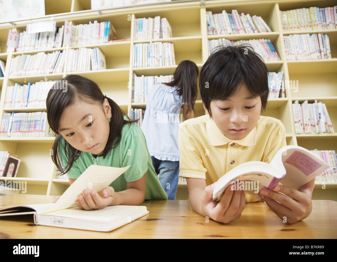 Elementary school students reading a book Stock Photo - Alamy
