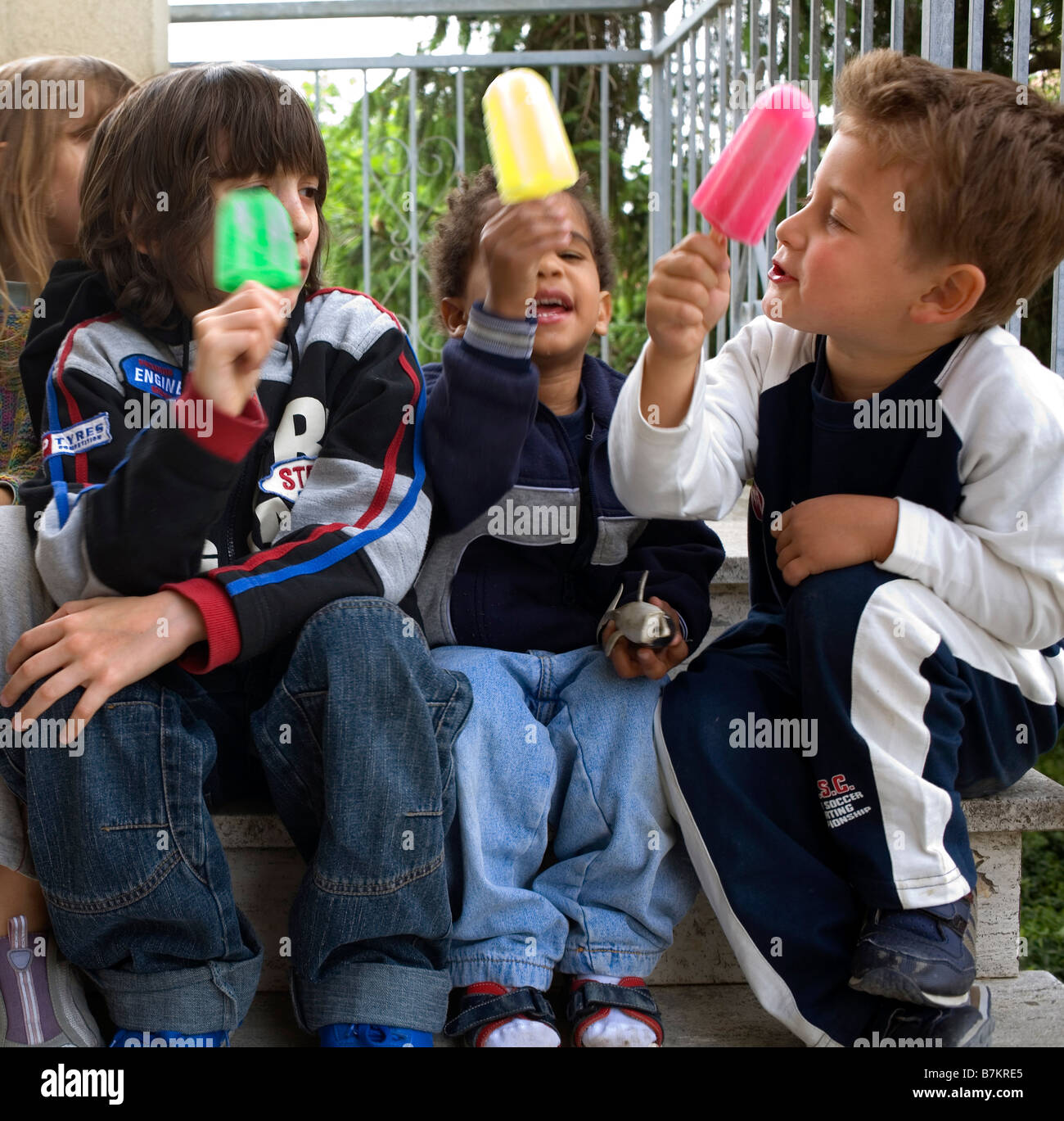 four children seated on steps eating popsicles Stock Photo - Alamy