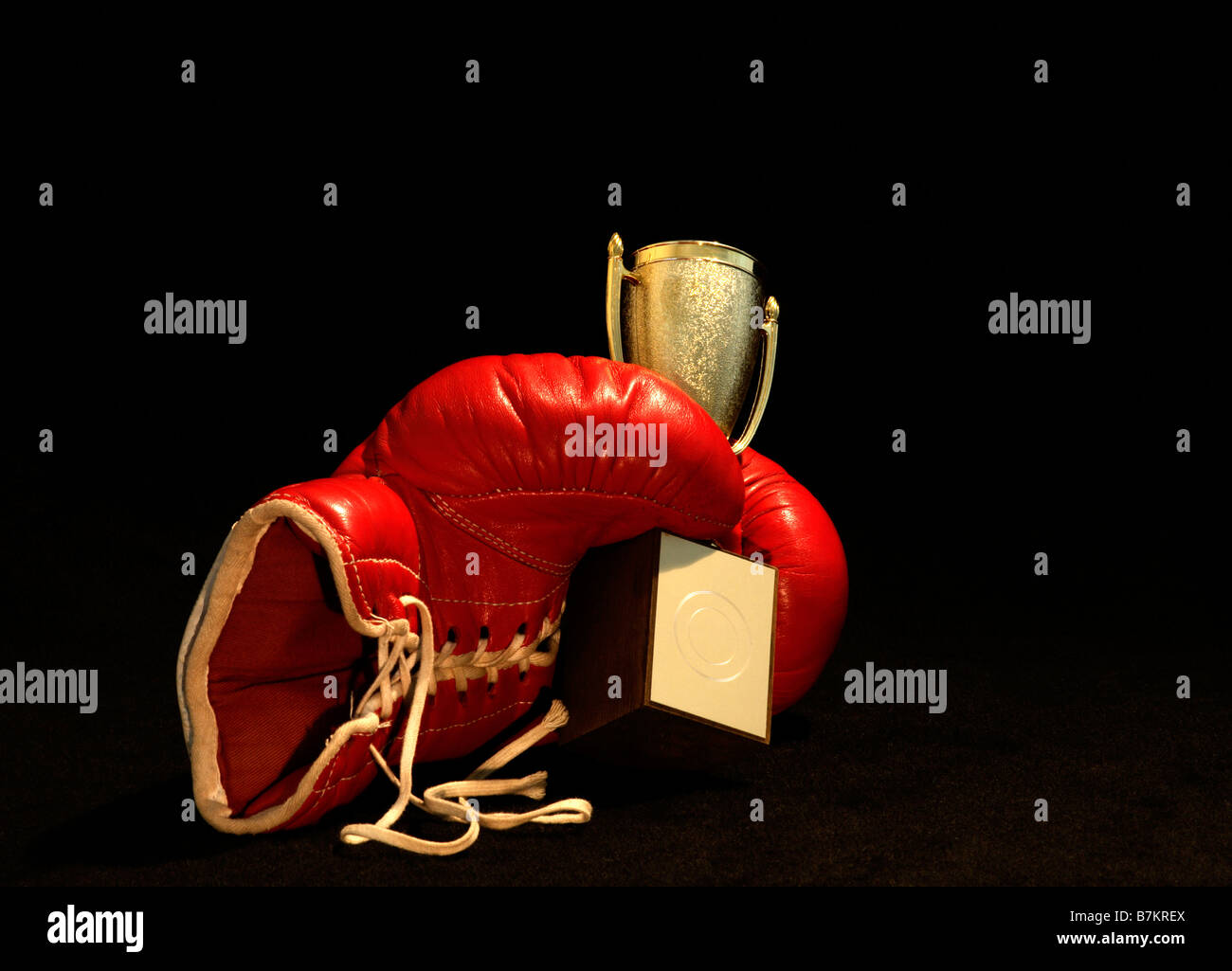 dark background and a red left hand boxing glove with a winner cup ...