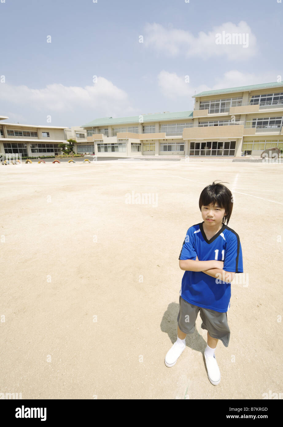 Elementary school boy standing on schoolyard Stock Photo - Alamy