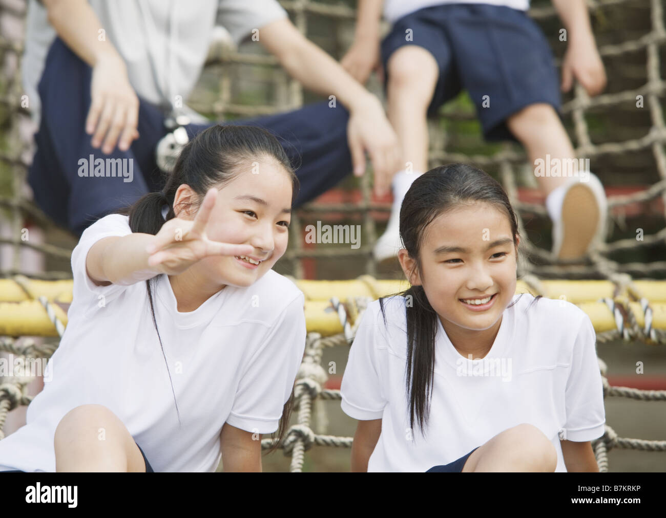 Elementary students sitting on play equipment Stock Photo - Alamy
