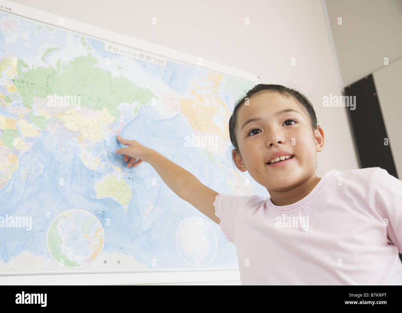 Elementary school girl pointing a map Stock Photo - Alamy