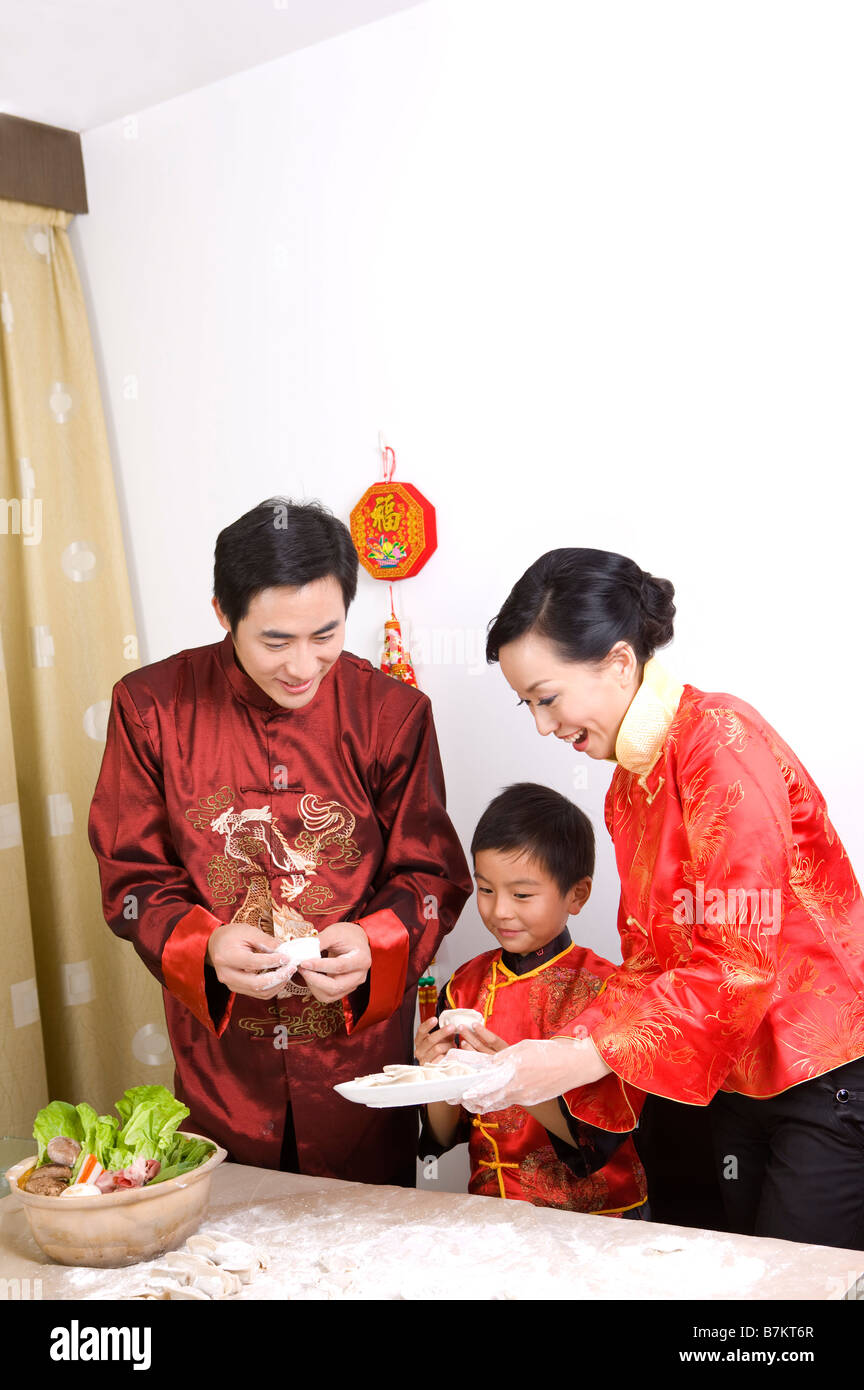 Family in traditional clothes making dumpling together Stock Photo - Alamy