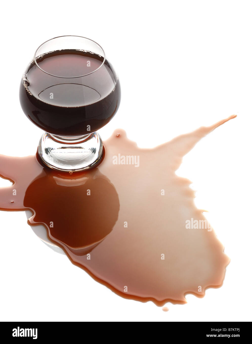 The spilled red wine Wine poured on a surface is isolated on a white ...