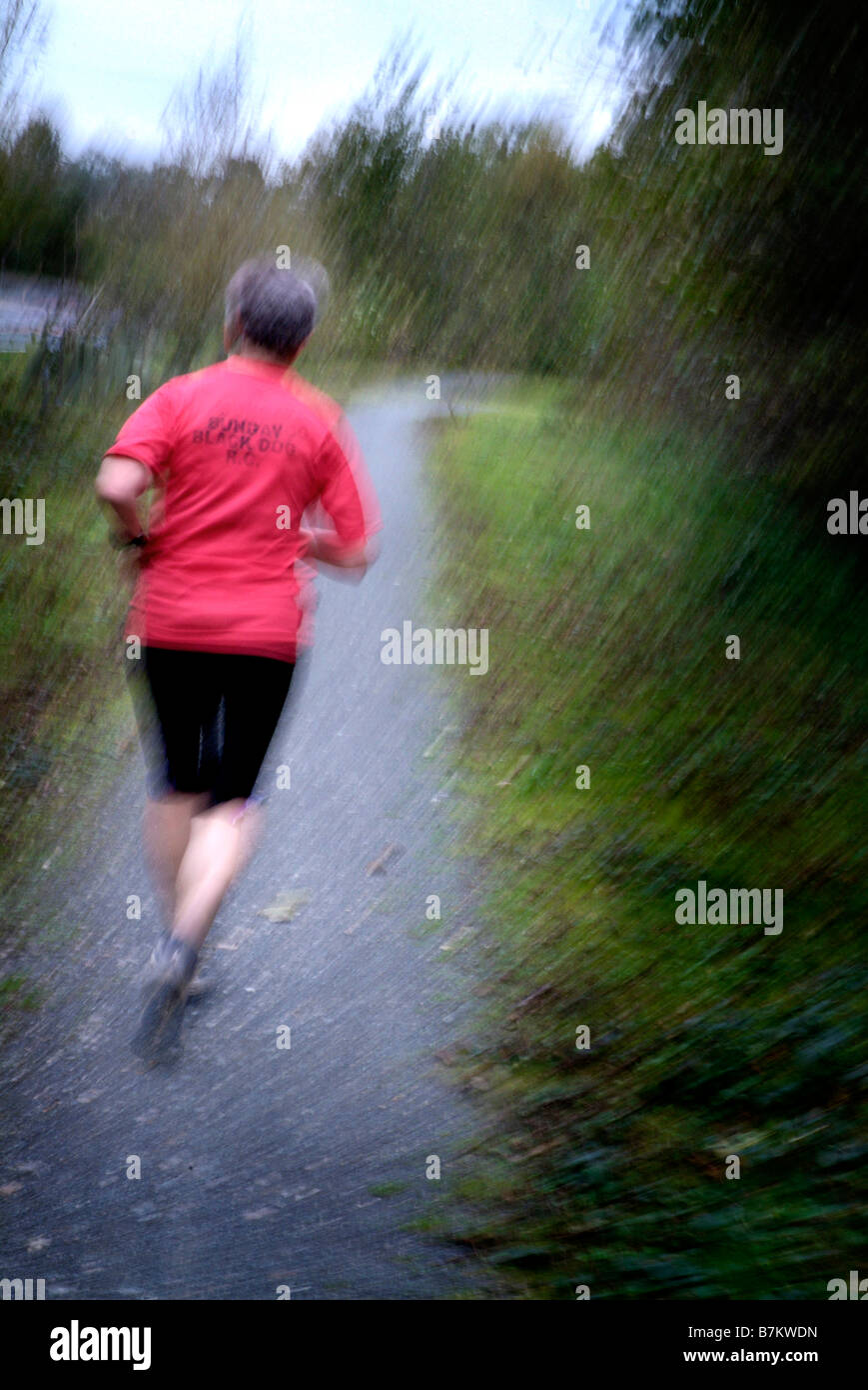 middle aged women running down track Stock Photo - Alamy