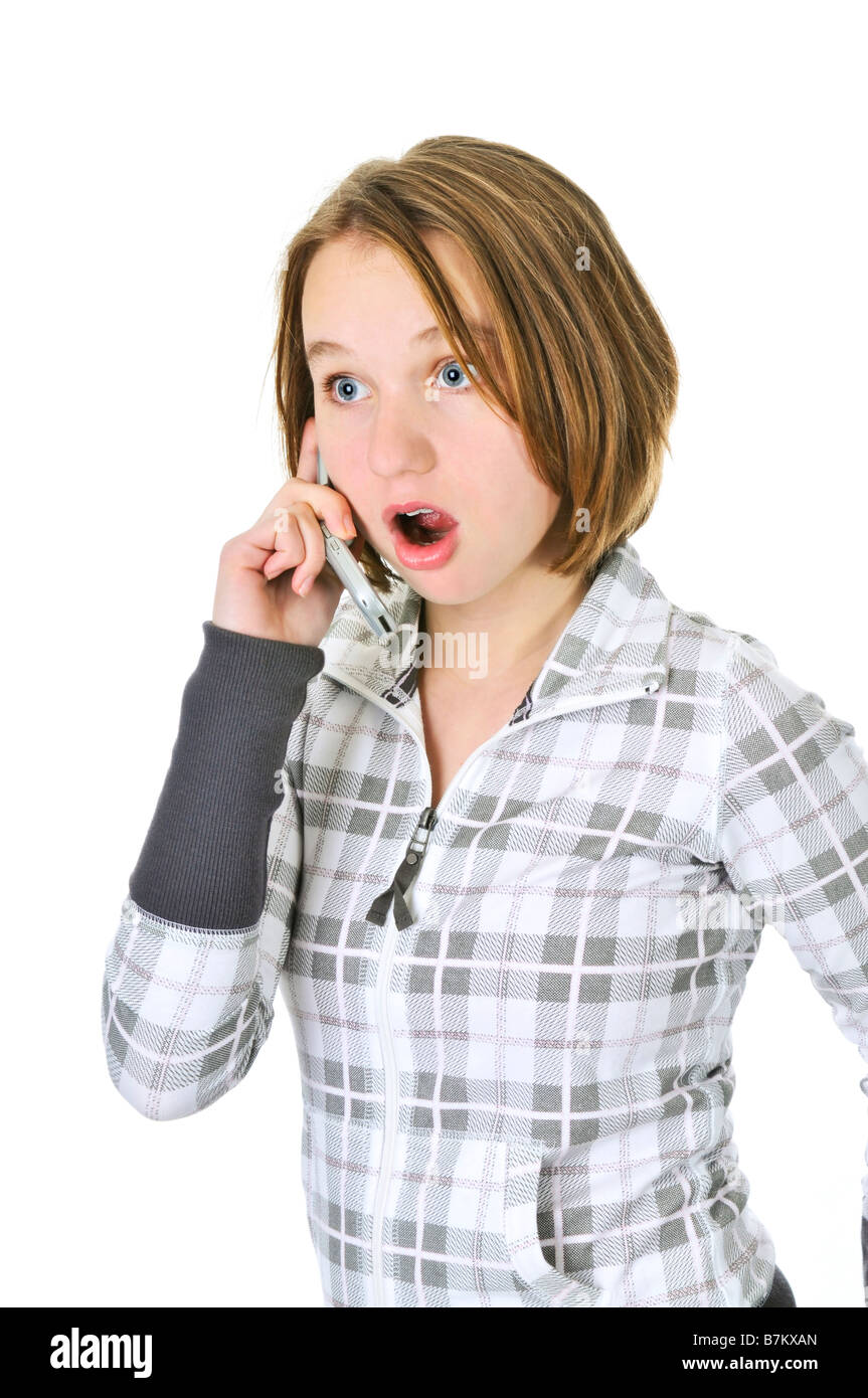 Teenage girl talking on a cell phone acting surprised isolated on white ...