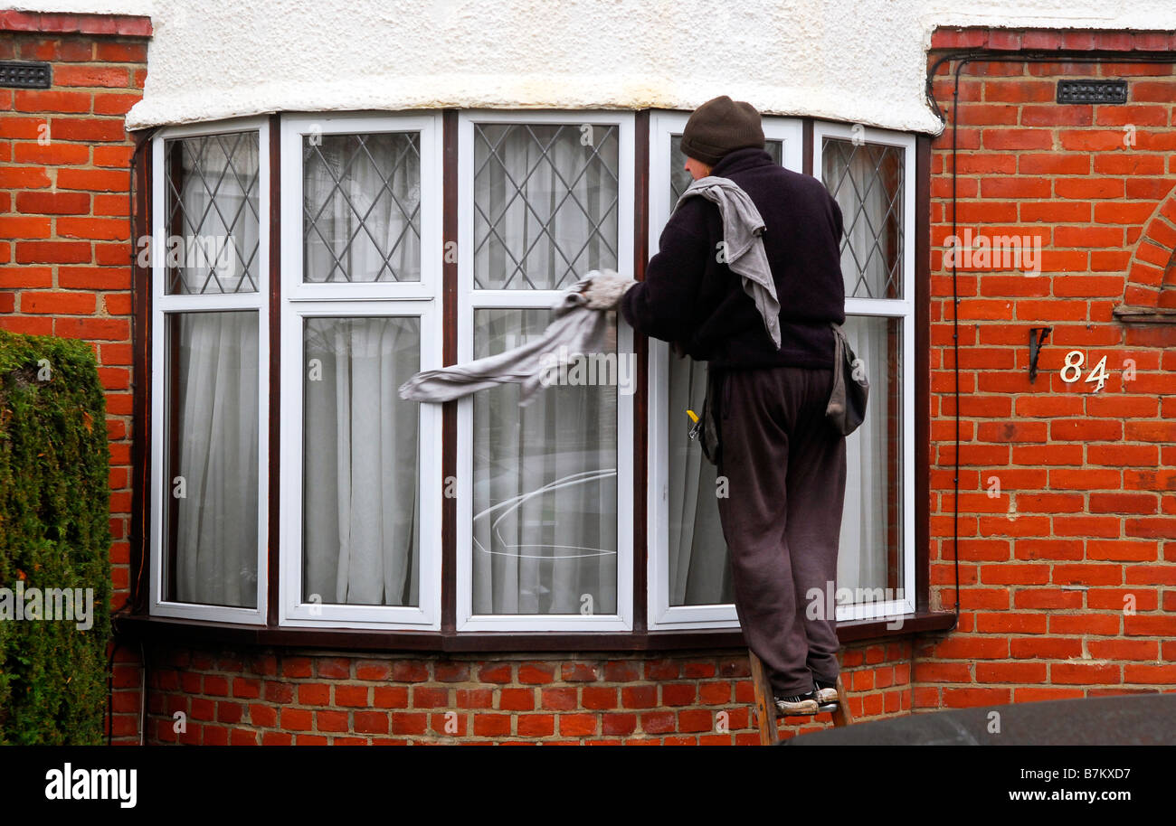 Window cleaner cleaning bay window of residential house, Hounslow ...