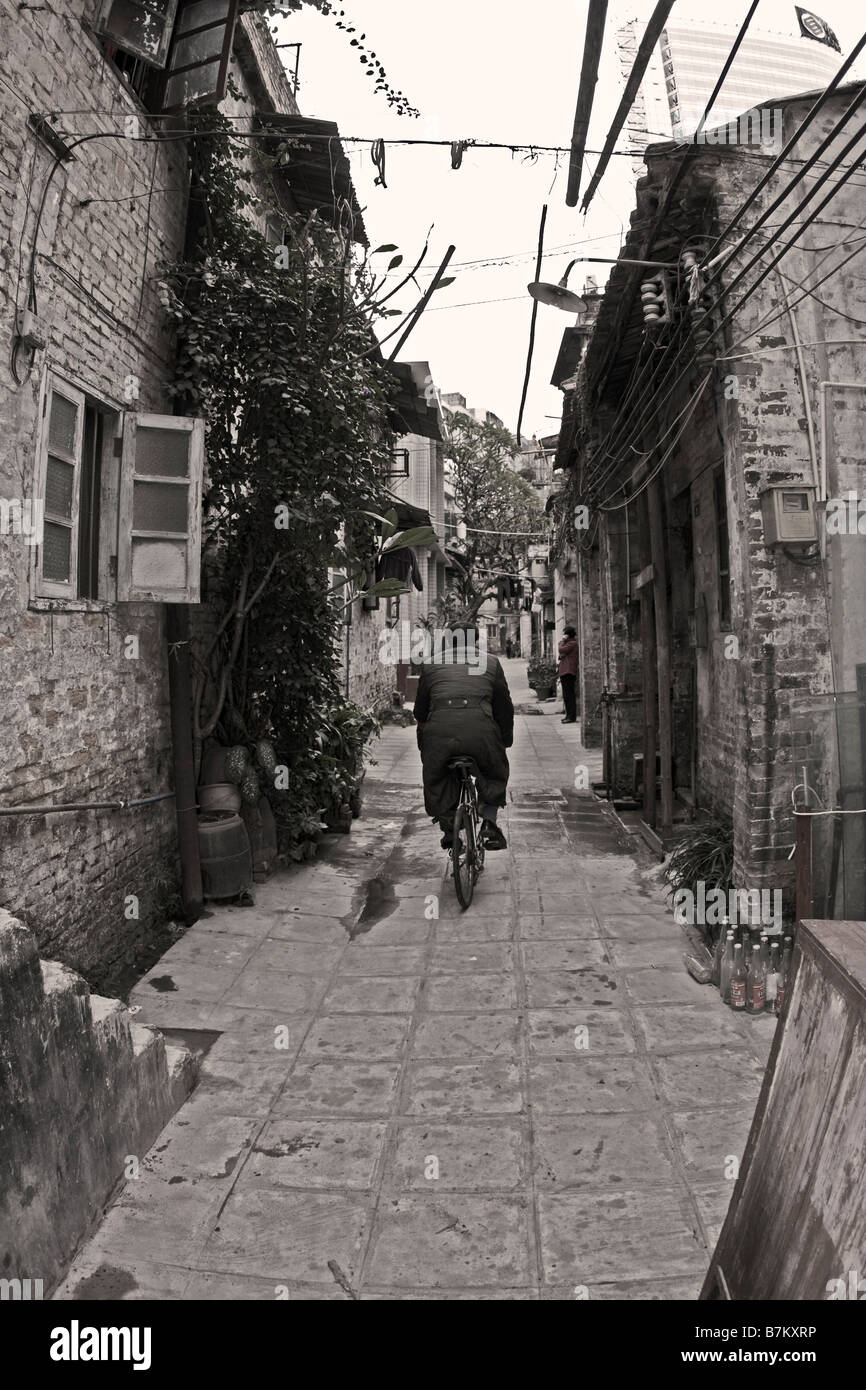 Chinese Man riding bike away down side street Good perspective and ...