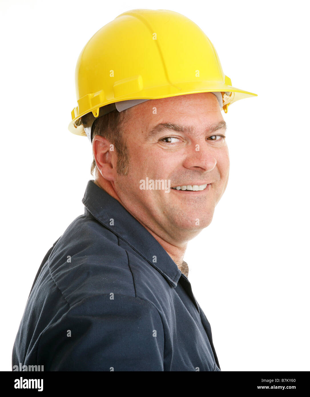 Portrait of a typical construction worker smiling in a hardhat against ...