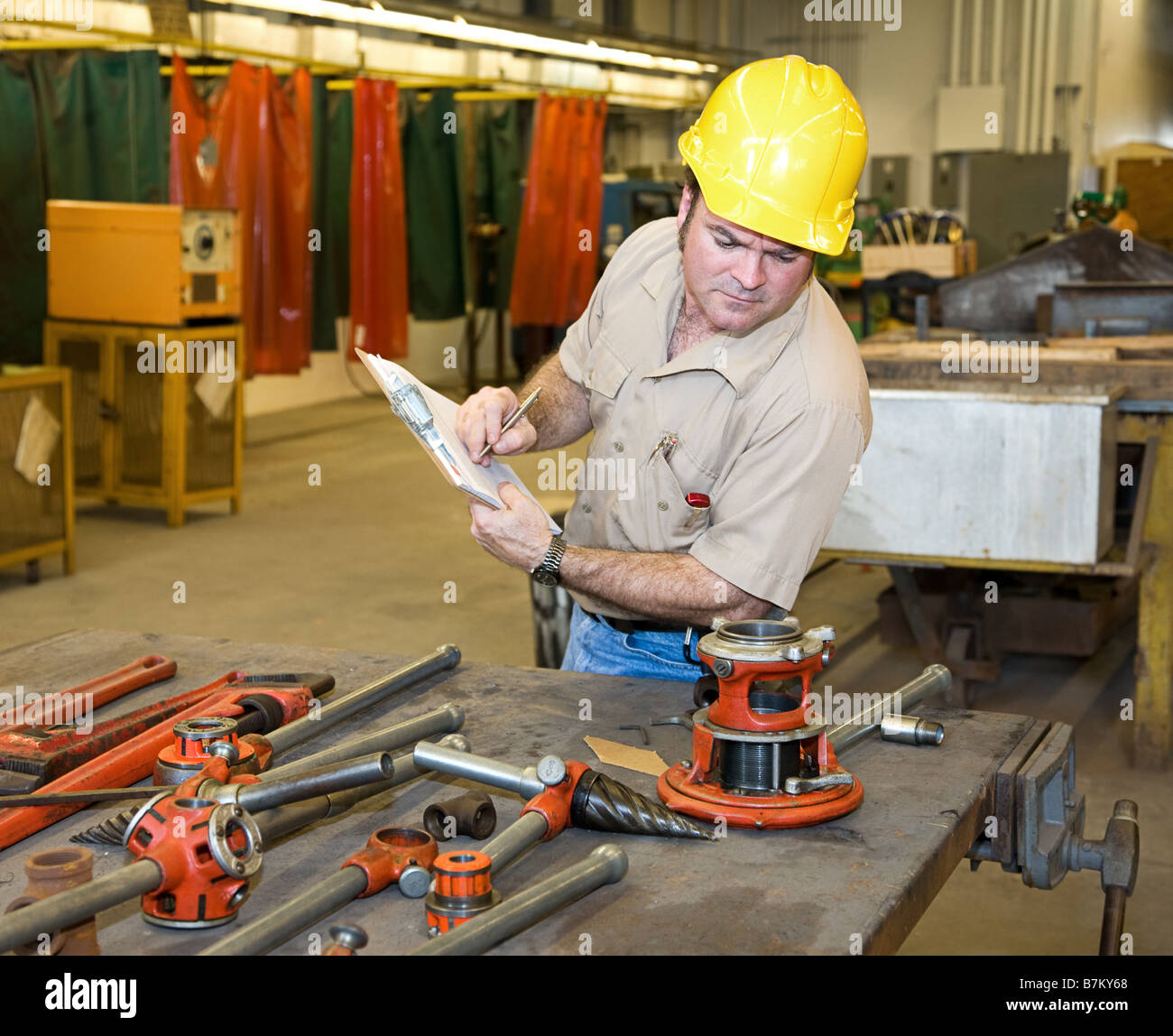 Inspector verifying the condition of available tools in a metal work ...