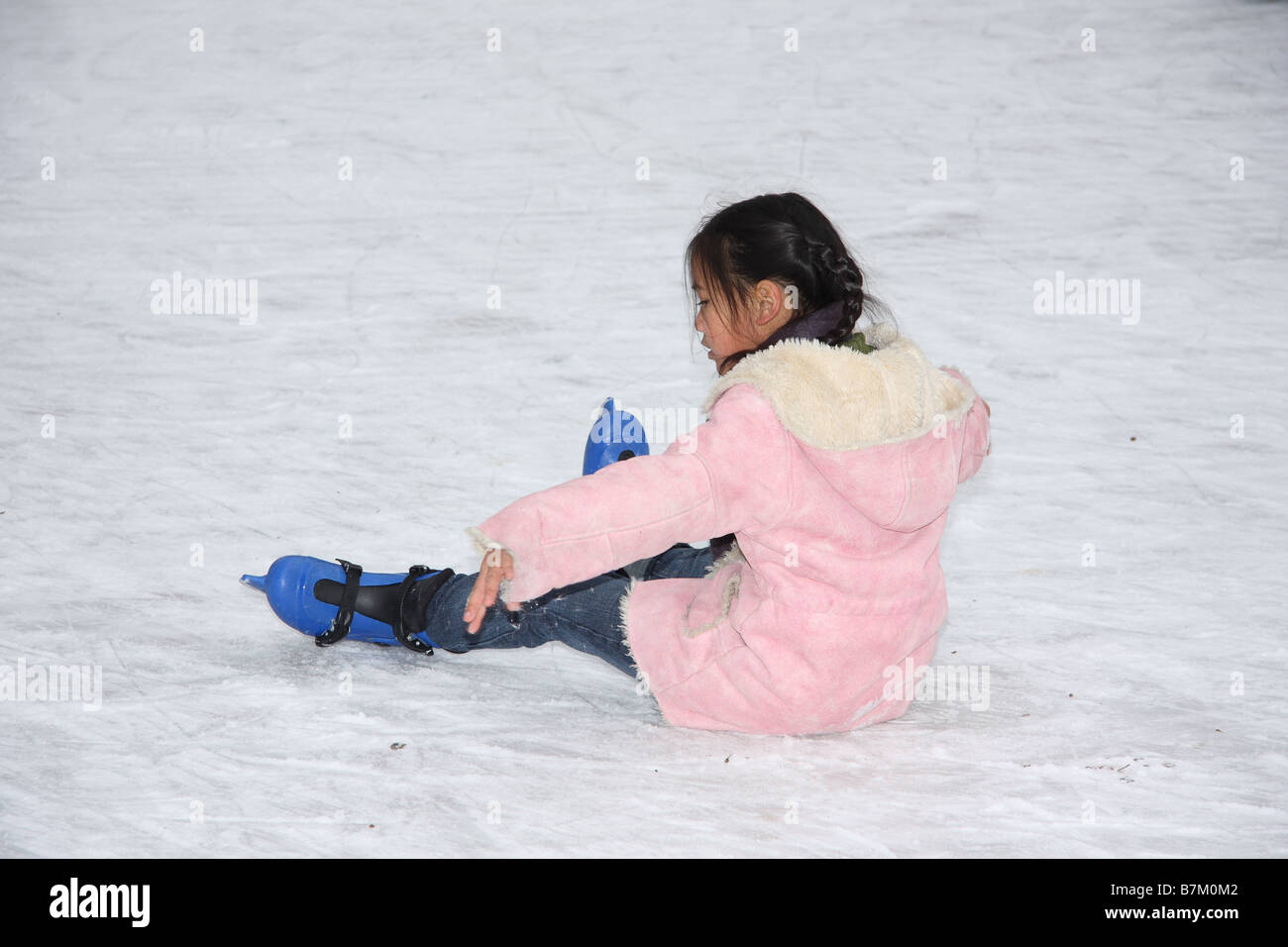 slip fall chinese girl ice skating skaters rink open air cold winter ...