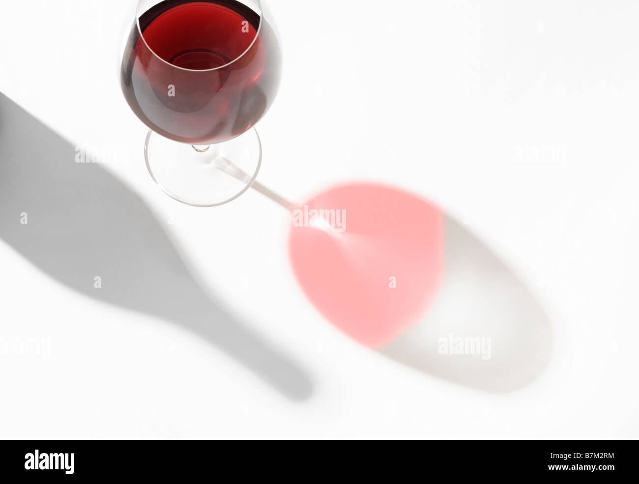 Shadows of a glass and bottle of red wine on a white surface Stock ...