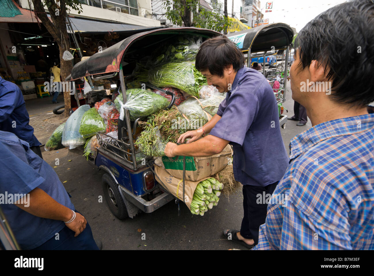 Auto rickshaw driver loading vehicle with vegetables Pak Khlong Talad ...
