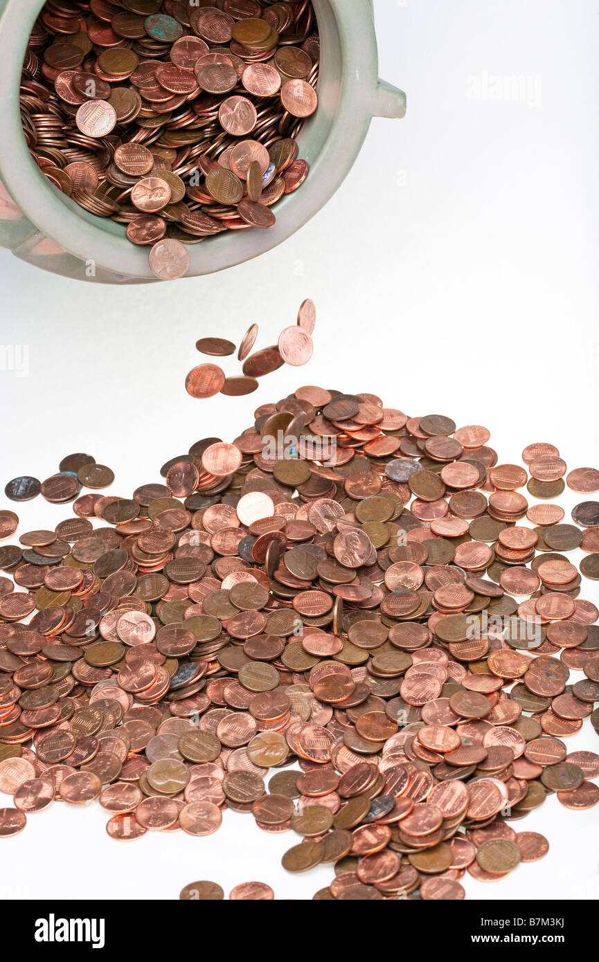A bowl full of pennies spilled out onto a white background Stock Photo ...