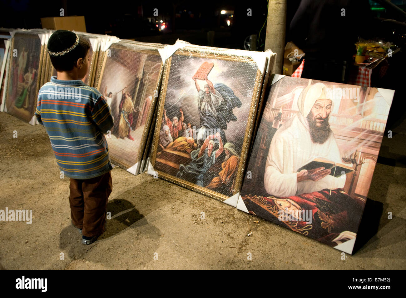 Young Sephardic Jew looking at souvenir religious paintings at the ...